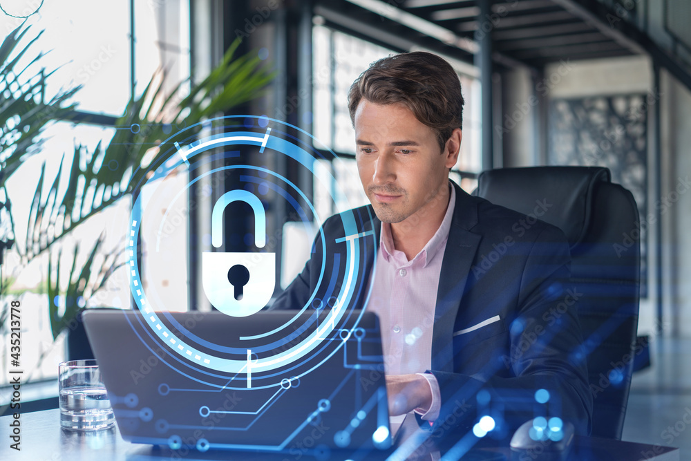 Handsome businessman in suit at workplace working with laptop to defend ...