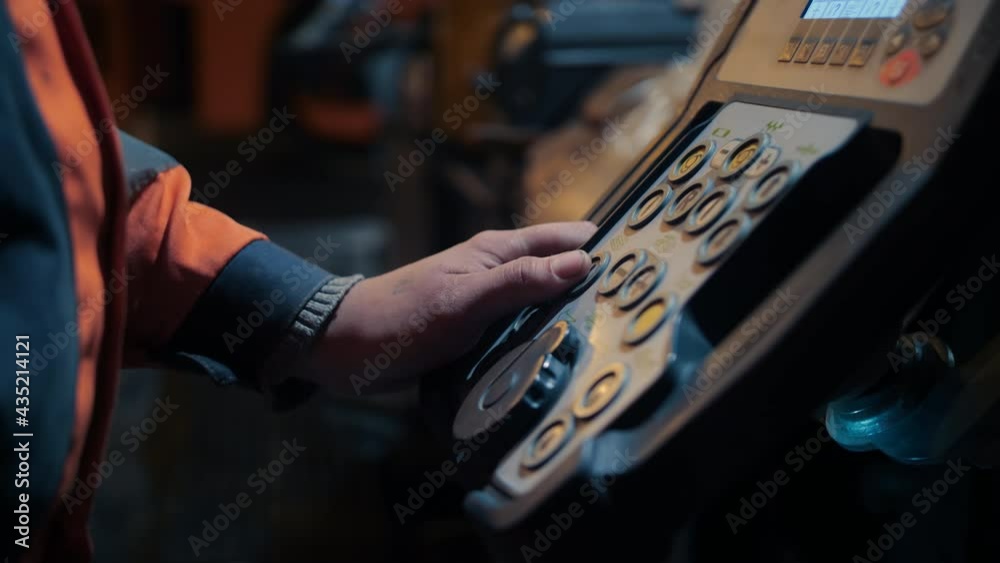 A close-up of the asphalt paver's control panel. Road worker's hand at ...