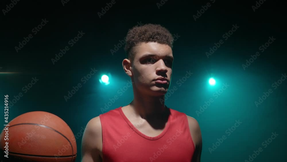 Portrait of young guy basketball player with a ball in hand. An athlete ...