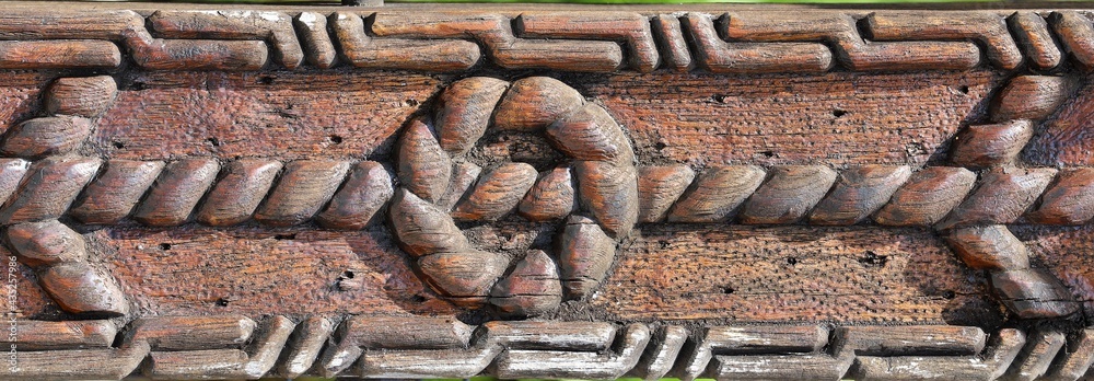 An old sculpture on the pillar of a gate in the city of Reghin ...