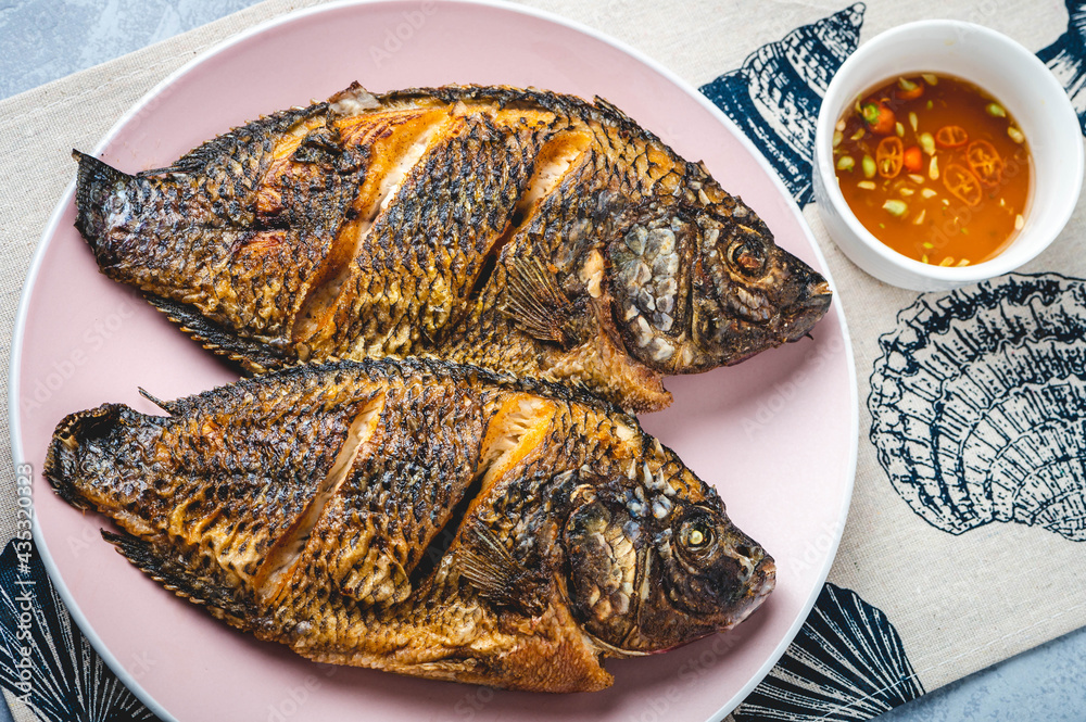 Famous Pinoy Ulam- Fried Tilapia with condiment on the side Stock Photo ...