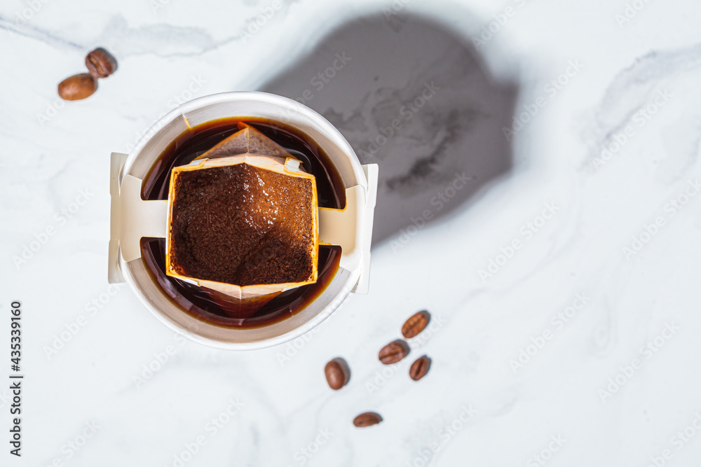 Making coffee with drip coffee bag in white paper cup, copy space ...