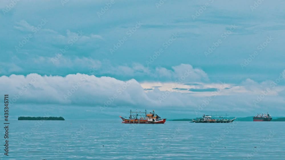 Fishing boats and tankers share waters of Surigao Strait Philippines. A ...