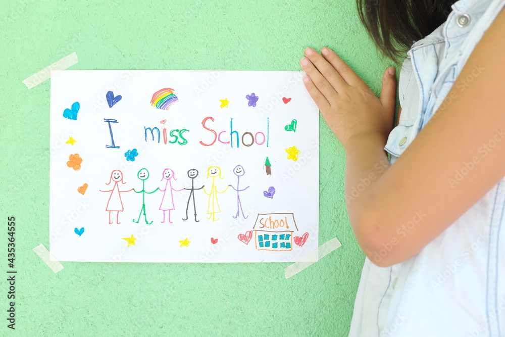 Foto de Child holding I miss School paper work drawing. Sadness in ...
