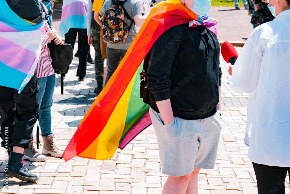 LGBT activist wrapped in flag taking a part in interview and talks ...