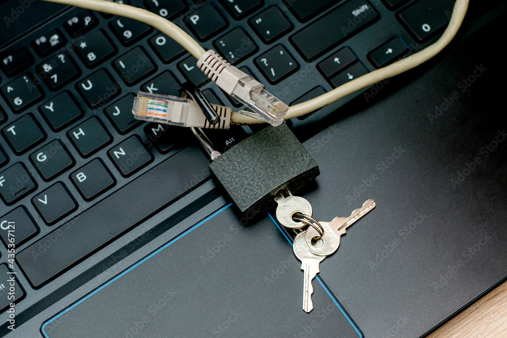 internet cable passing through an open iron lock with keys on a laptop ...