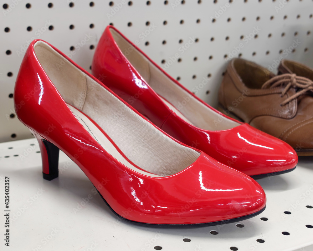 Shiny red high heel shoes on display shelf. Stock Photo | Adobe Stock