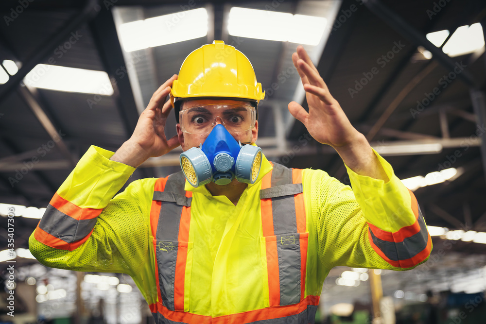 Factory male worker in safety uniform, gas mask showing hands and ...