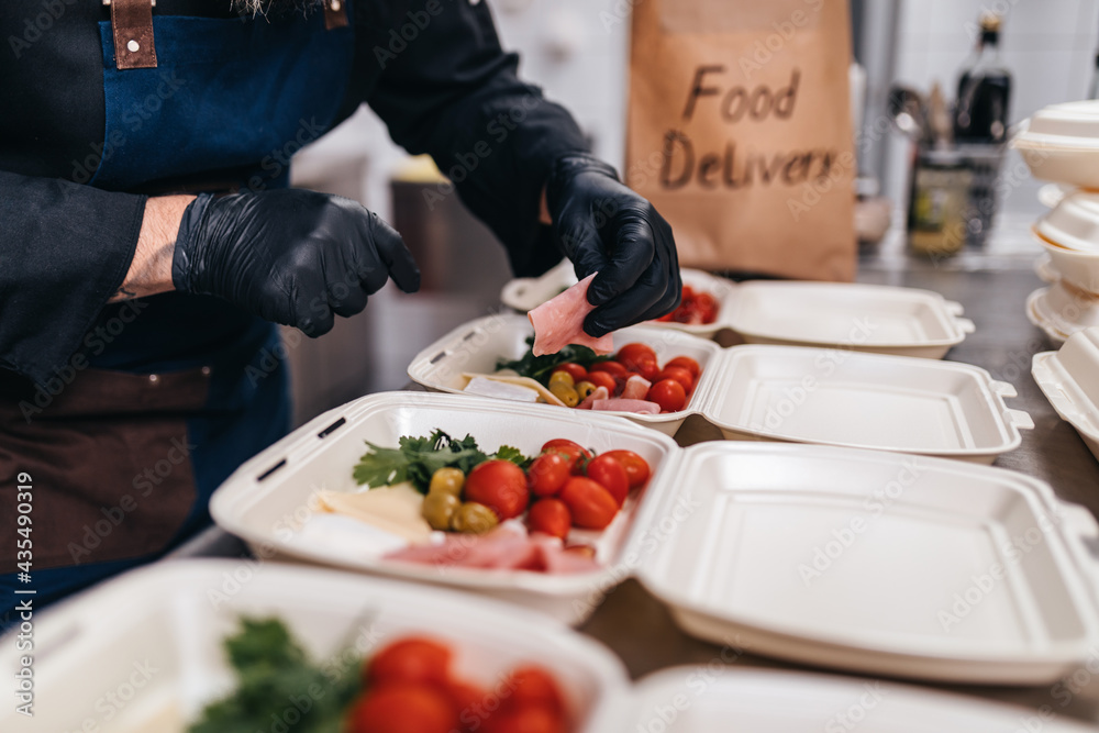Food in disposable dishes ready for delivery. The chef prepares food in ...