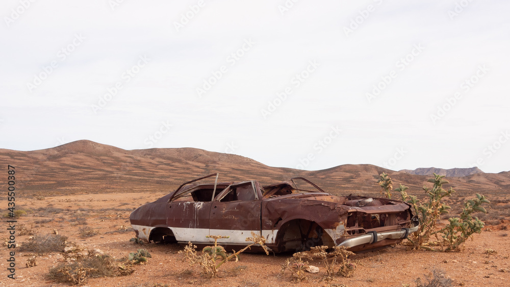Abandoned rusted car wreck in a desert. The car rolled in the accident ...