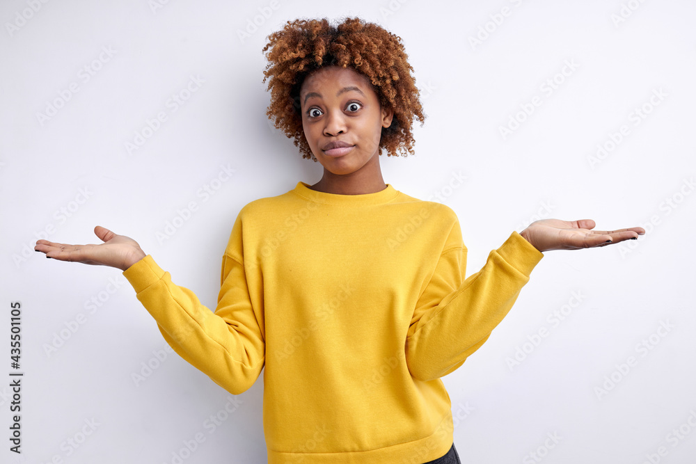 Clueless African woman shrugs shoulders with hesitation, faces doubtful ...