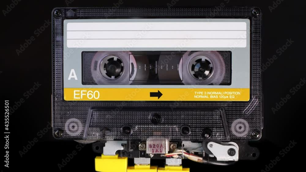 Vidéo Stock A yellow, vintage, compact cassette tape playing back in a ...