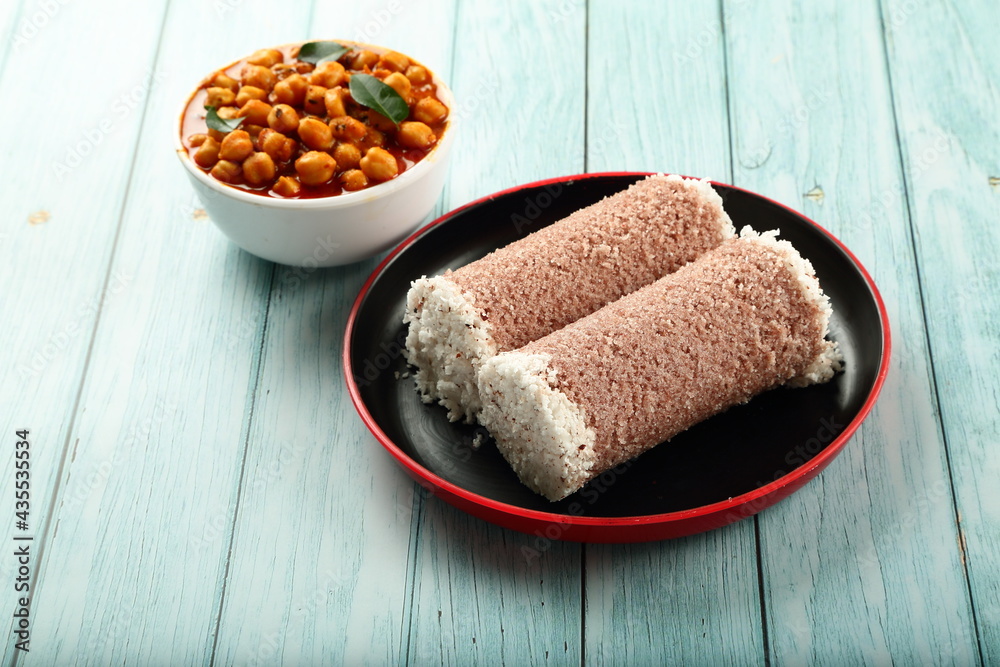 Homemade delicious steamed red rice puttu served with chickpeas curry ...