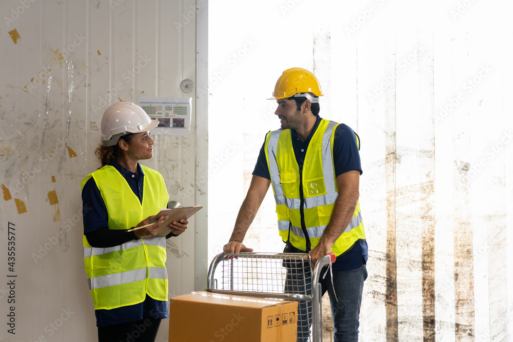 Worker wear safety helmet and holding clipboard and push cart in ...