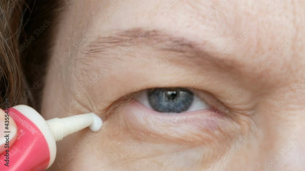 middle-aged woman does corrective eye makeup to correct the drooping ...