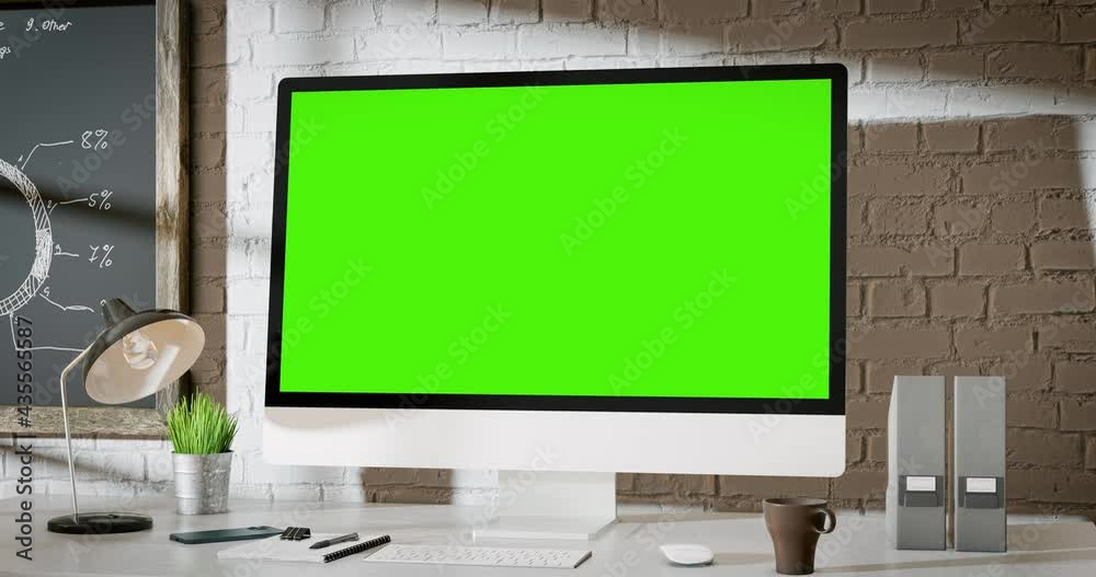 Computer all-in-one with a blank green screen in vintage loft office ...