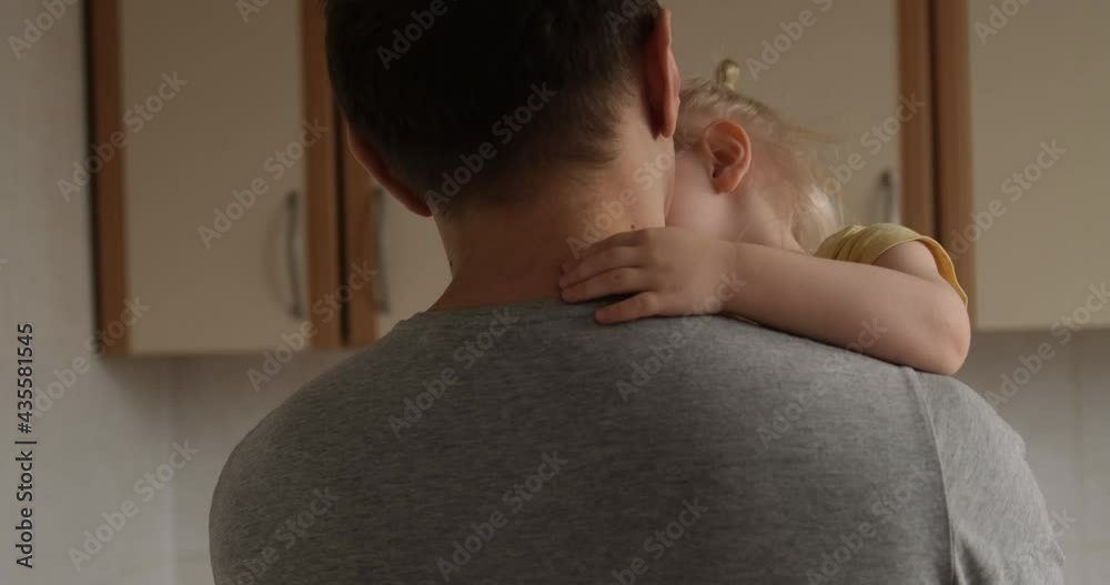 Little blond girl gently hugs her dad. Baby in his father's arms ...
