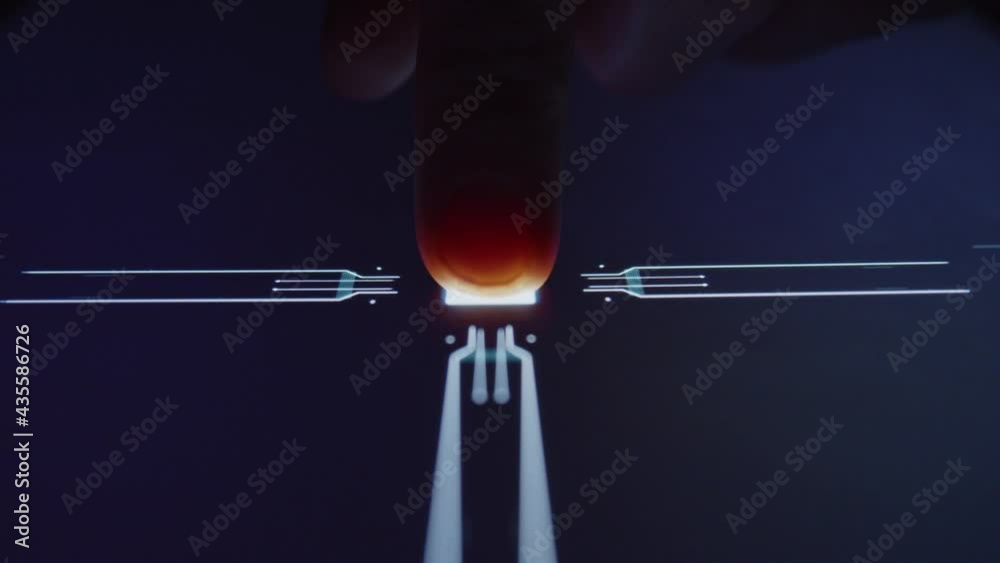 Dark shot of human finger turns on touch screen button and activates ...