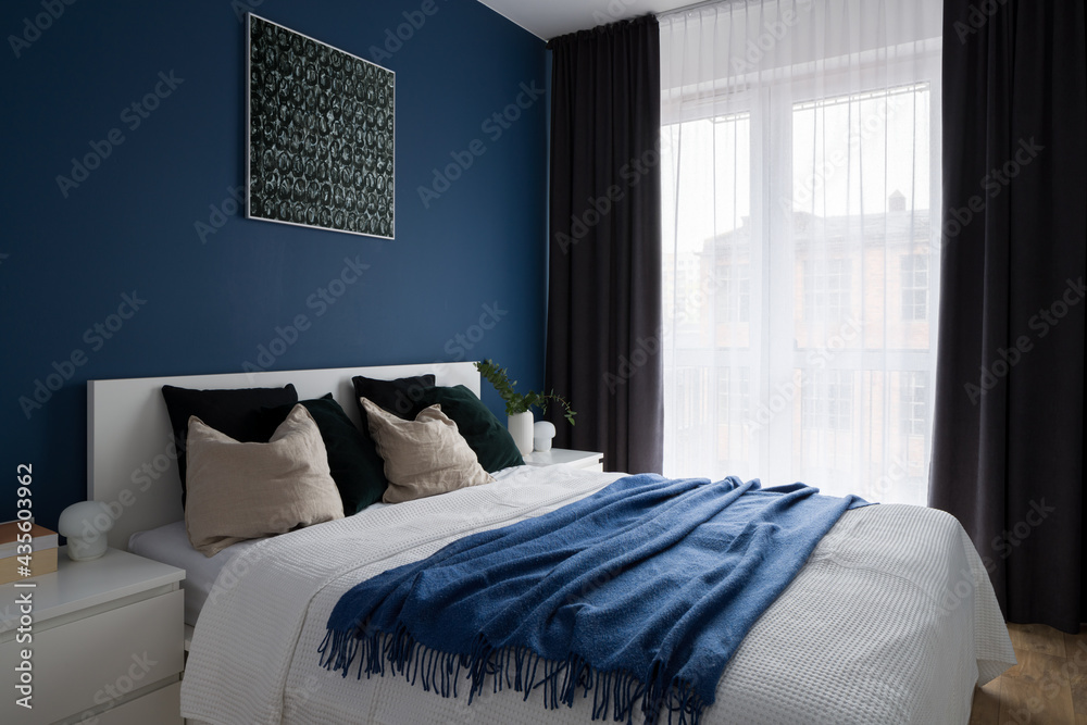 Comfortable bedroom with modern blue wall Stock Photo | Adobe Stock