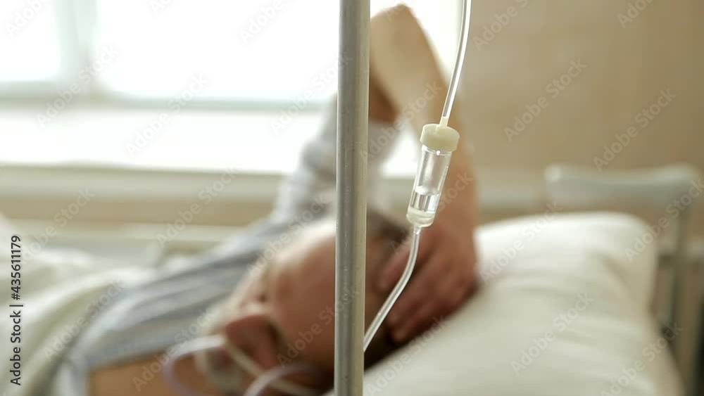 Drops in a dropper in the hospital ward unrecognizable patient lies in ...