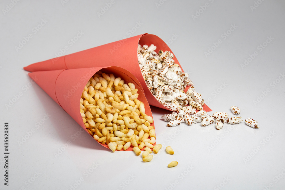 puffed rice and popped rice in pink paper packet on white background ...