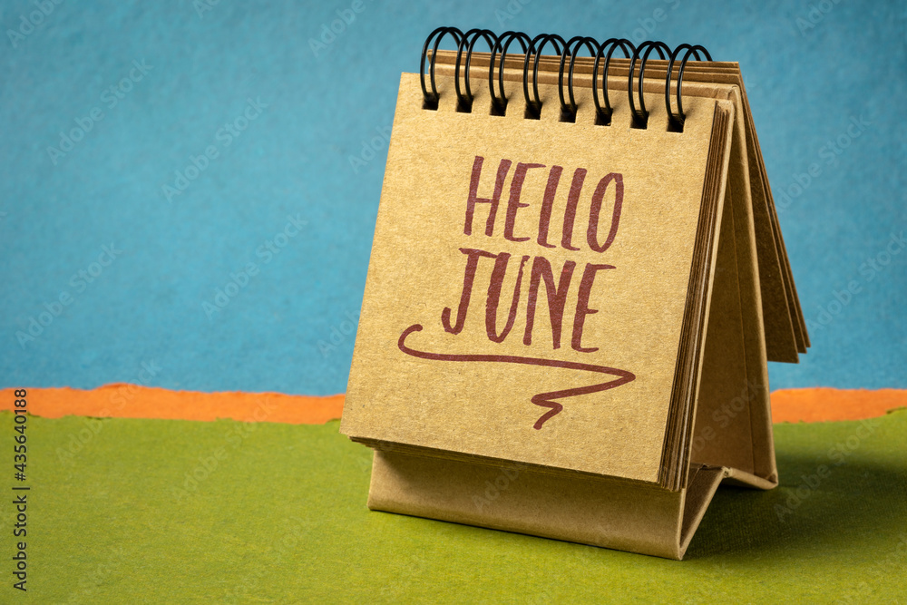 Hello June - handwriting in a desktop calendar against abstract paper ...