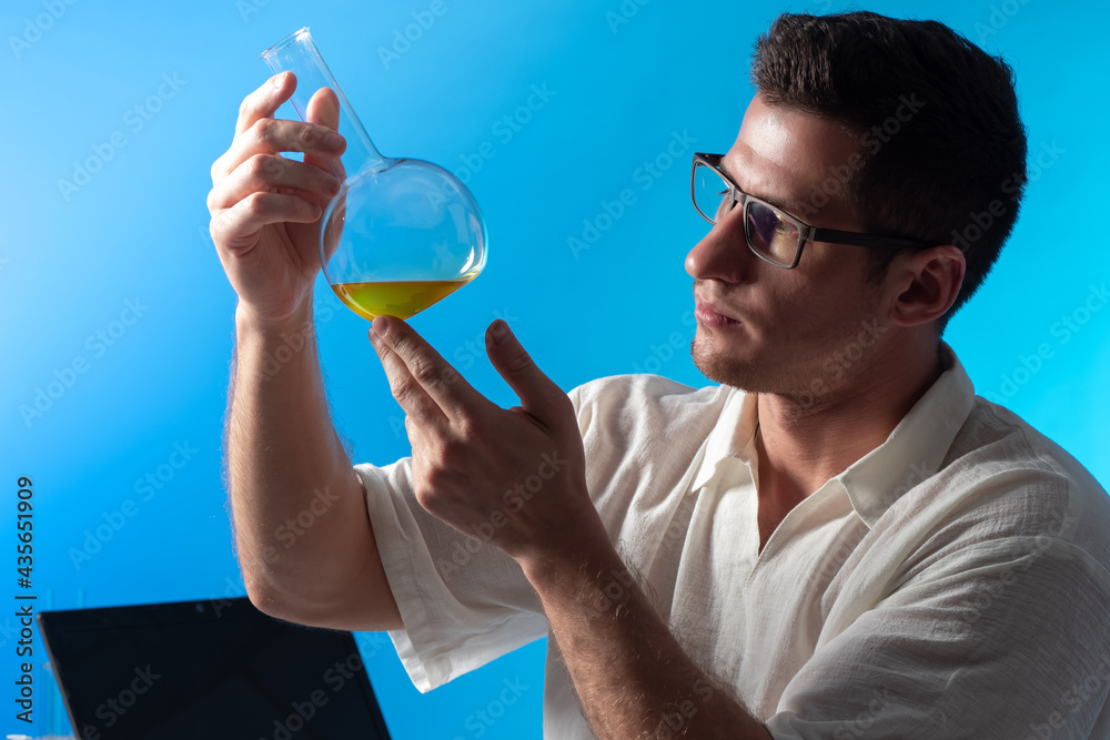 Male biologist with a large flask. Young man works as a biologist. He ...