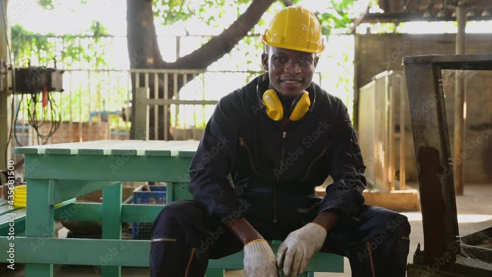 Portrait of African American workman wearing uniform and yellow safety ...