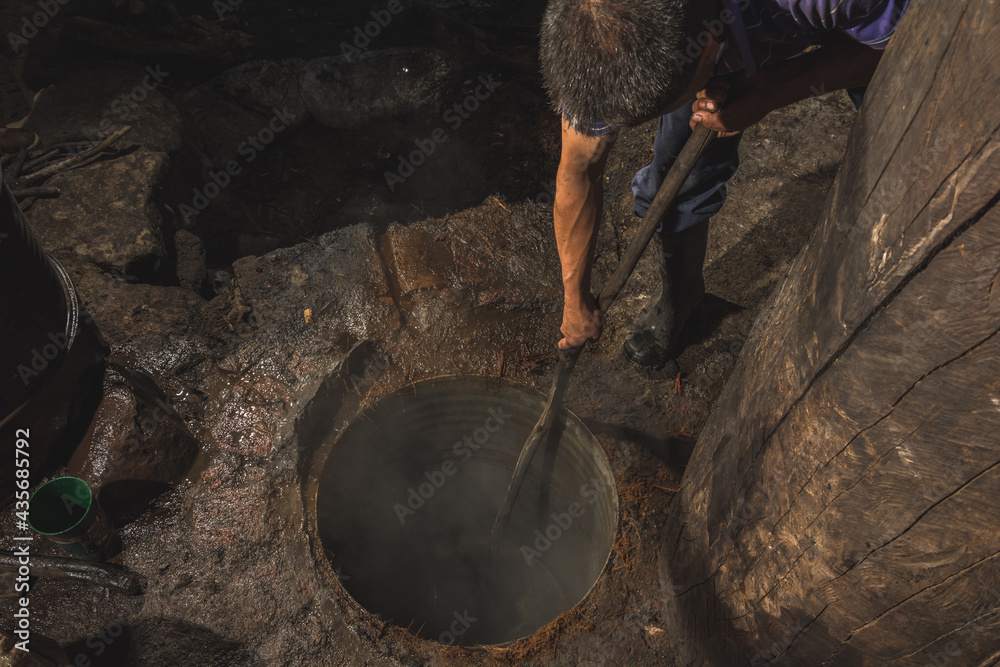 Mezcal master cooking the pineapple from the agave to extract the juice ...