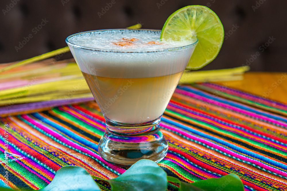 Traditional Peruvian pisco sour cocktail with a slice of lime foto de ...