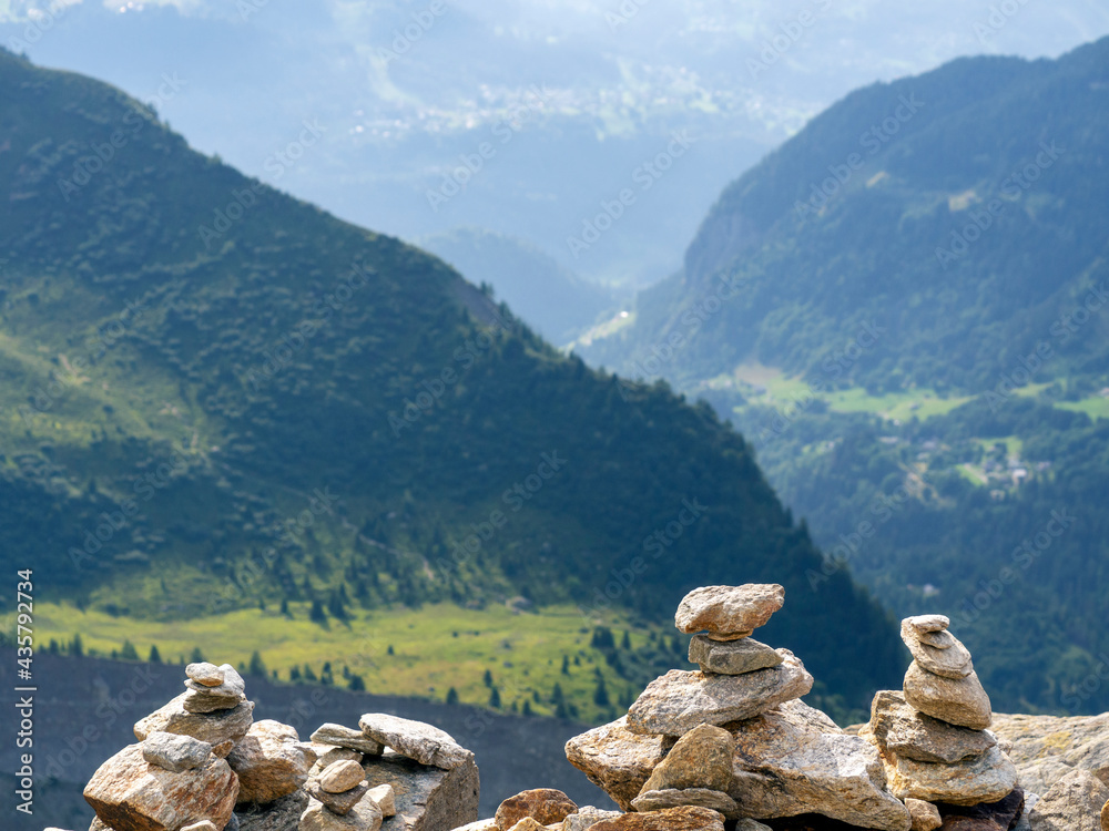 Cairn are stacked at the edge of the cliff. Mountains and forests are ...