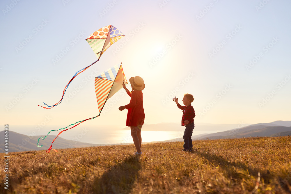 happy children girl and boy launches a kite at sunset outdoors Stock ...