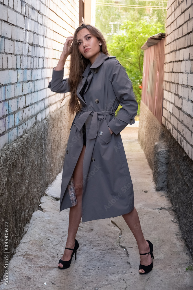 gorgeous asian attractive model wearing trench coat standing near wall ...