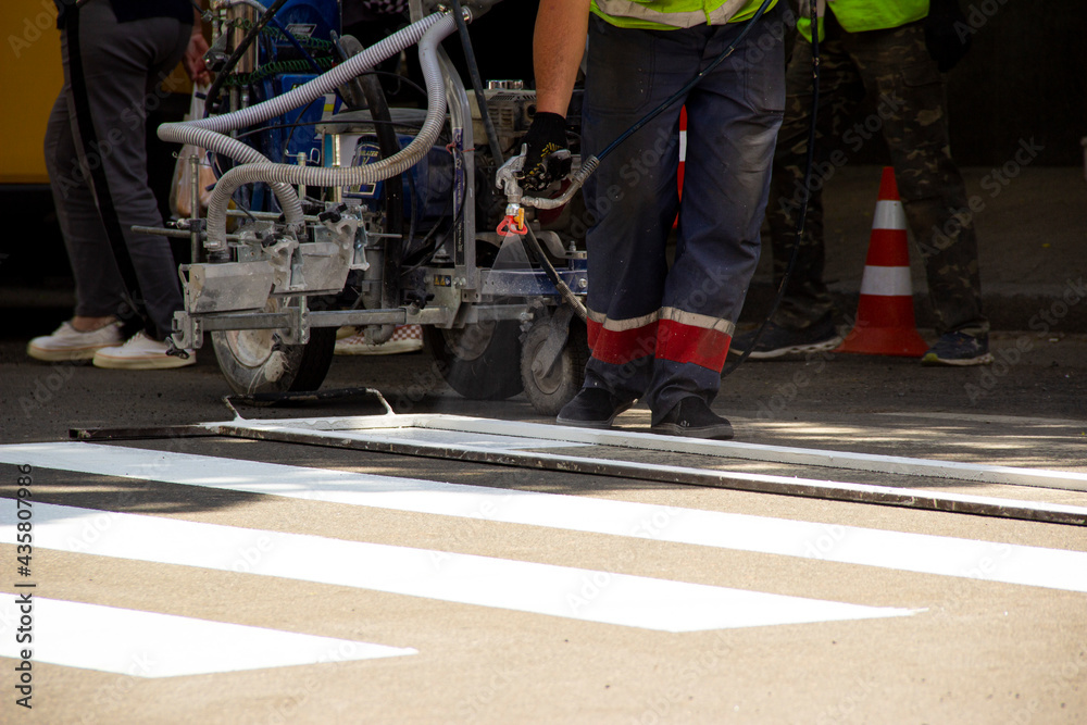 Worker applies road markings, markings for cars Stock Photo | Adobe Stock