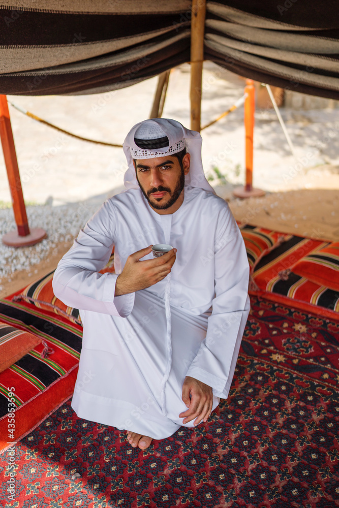 Arab man in traditional dress drinking arabic coffee in majilis Stock ...