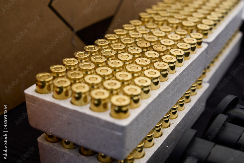 Boxes of brass casing 9mm pistol caliber ammo sitting on a table at the ...