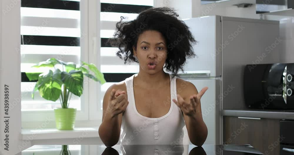 An Angry African American Woman Sits At A Table In The Kitchen And