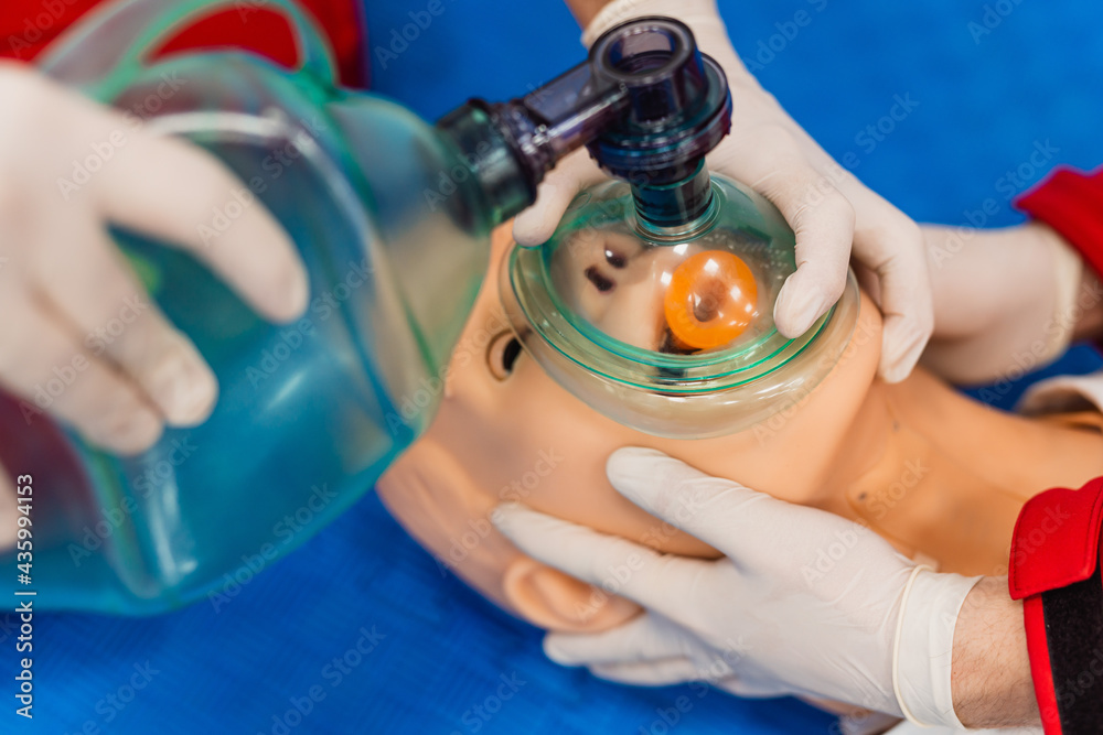 Hands holding a ambu bag on dummy patient, first aid training, CPR ...