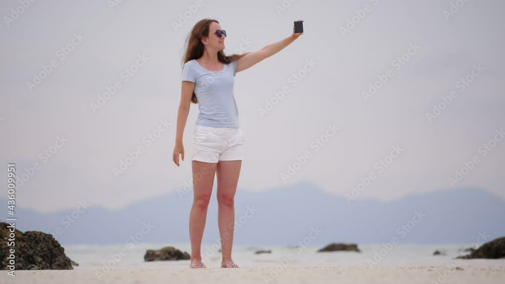 Tourist woman take selfie video at low tide beach, using smartphone ...