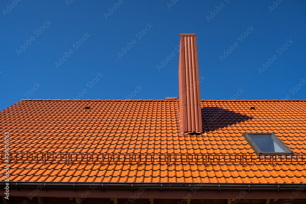 Red corrugated metal profile roof installed on a modern house. The roof ...