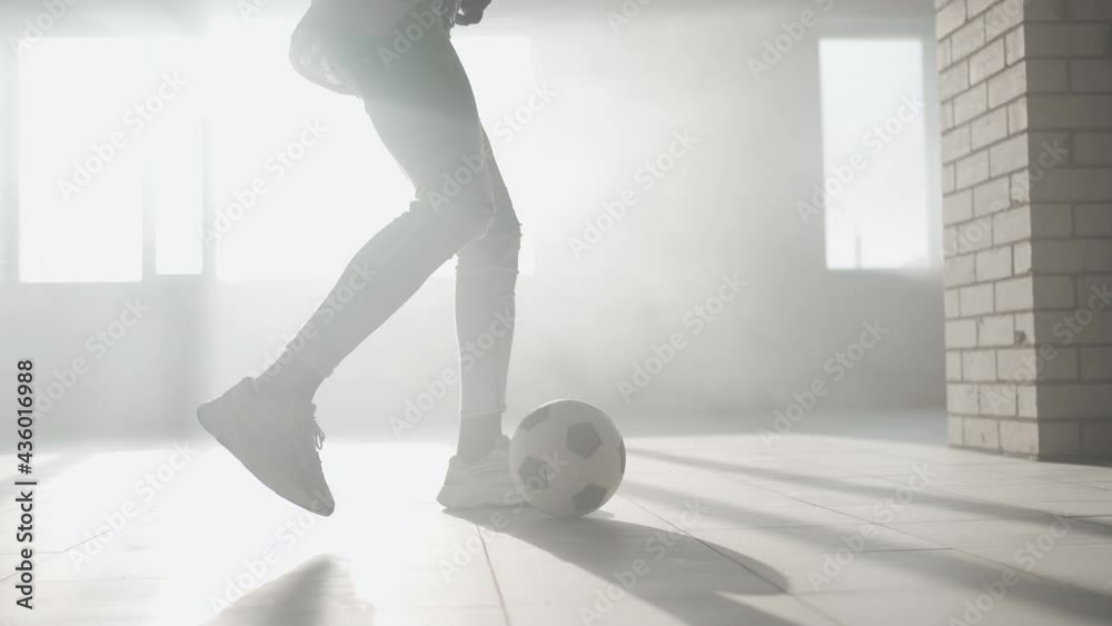 Close-up football dribbling in slow motion in an underground parking ...