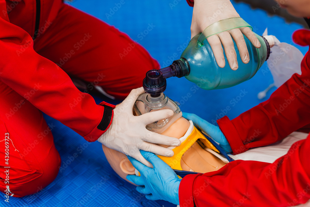Demonstrating CPR (Cardiopulmonary resuscitation), hand holding a ambu ...