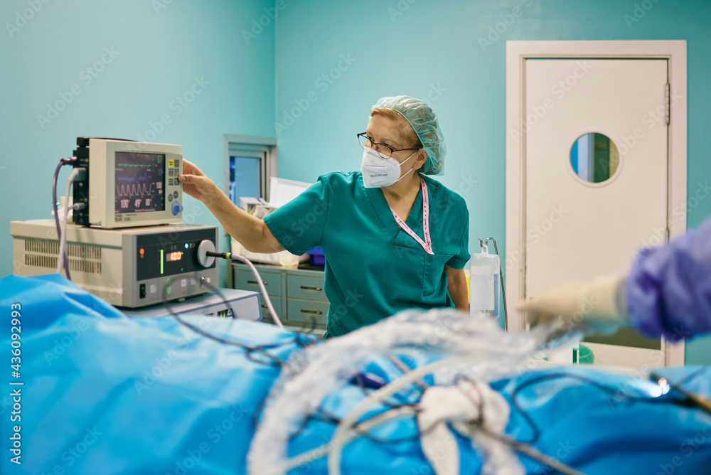 caucasian female nurse calibrates instruments in the operating room ...