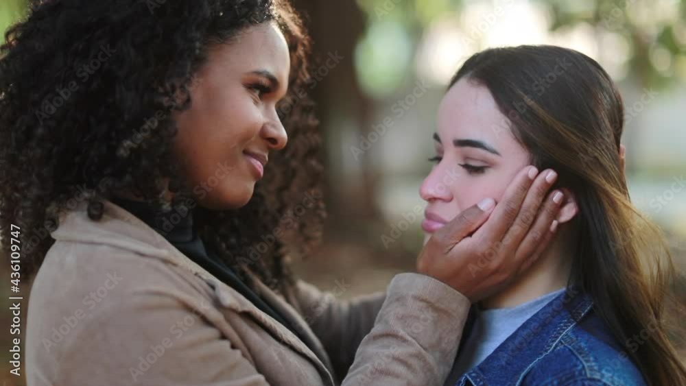 Two young women hugging in support and empathy together, two diverse ...