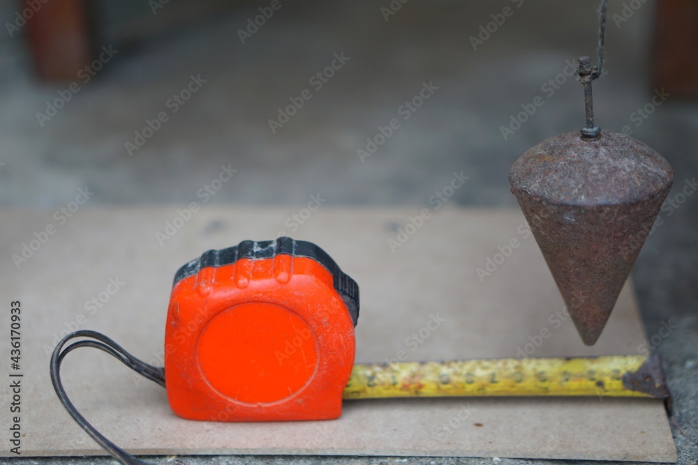 Close up photo of old measure tape and metal plumb bob. Tools for ...