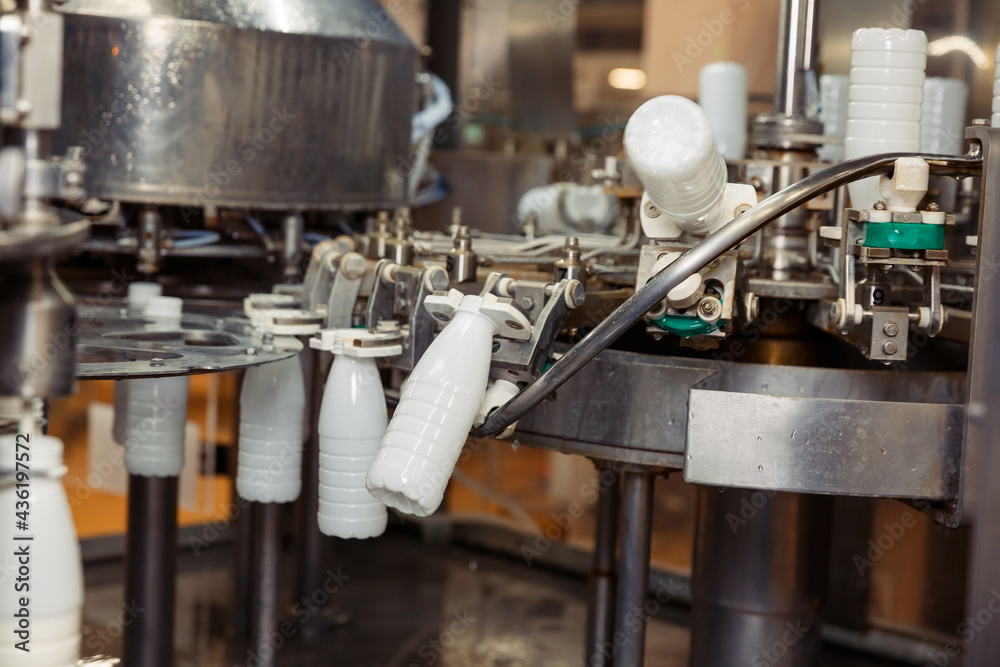 filling milk in to plastic bottles at the factory. equipment at the ...