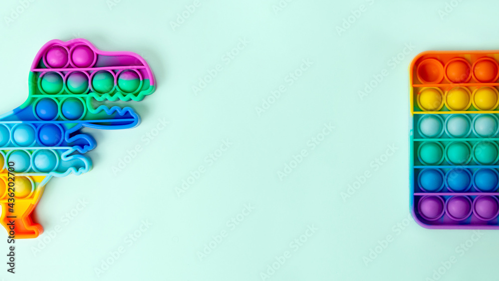 Large banner with copy space with two pop it toys on it.Dinosaur-shaped ...