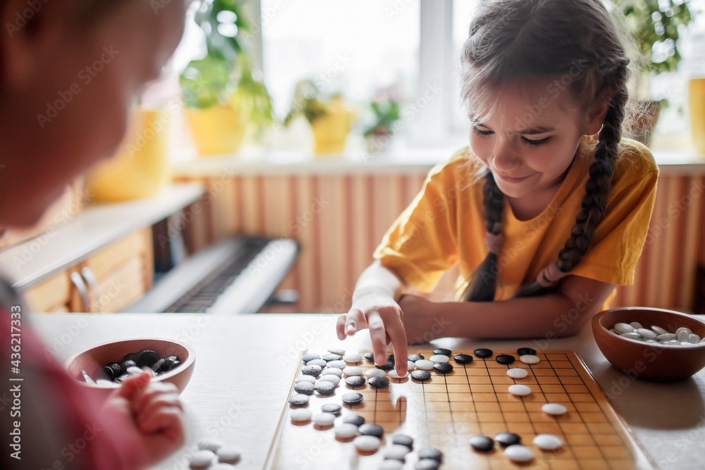 Brother and sister playing Chinese chess go at home, sibling have fun ...