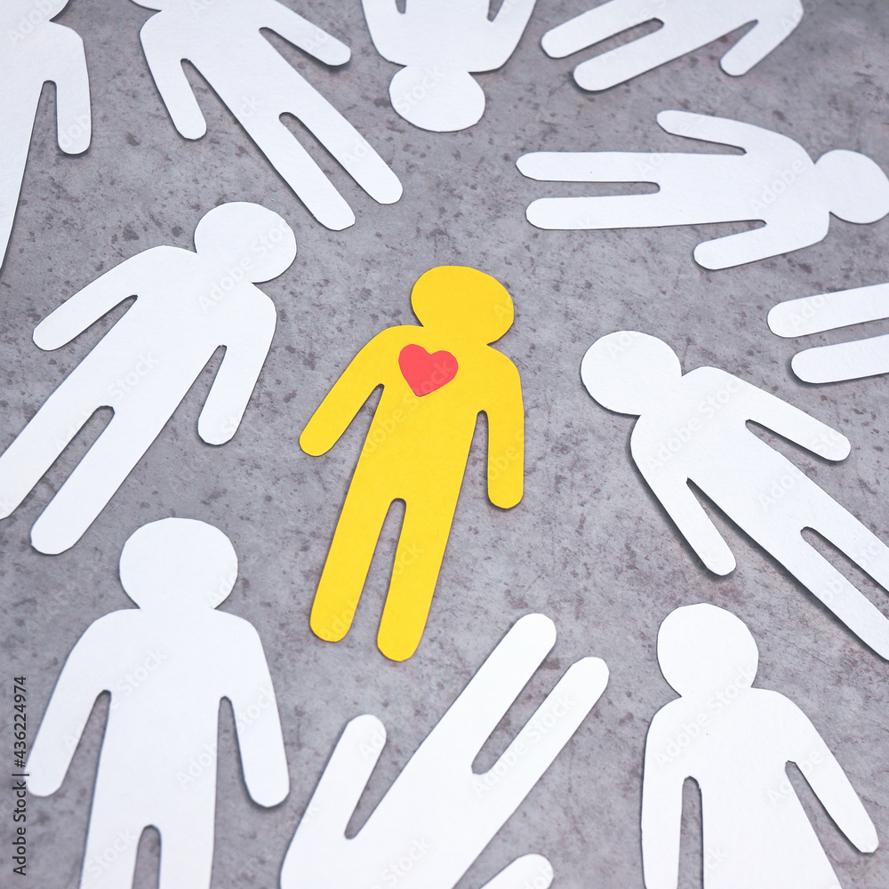 Paper-cut figures. In center is yellow man, with red heart in chest ...