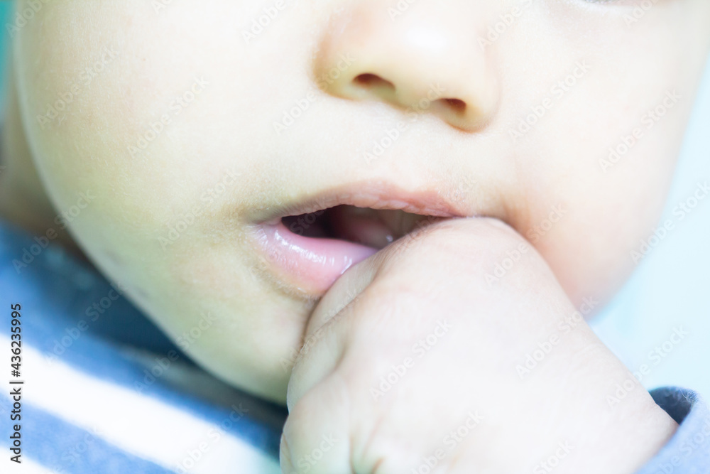Asia Portrait of a cute baby, (newborn anima) bites hand.The very happy ...